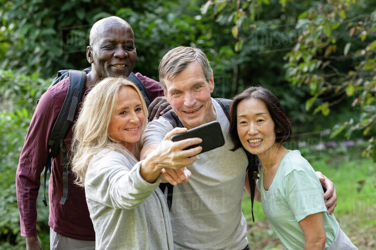 Diverse group of middle-aged friends taking a selfie while out on the ...