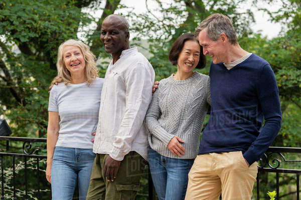 Diverse group of couples having a good time outdoors in public park ...