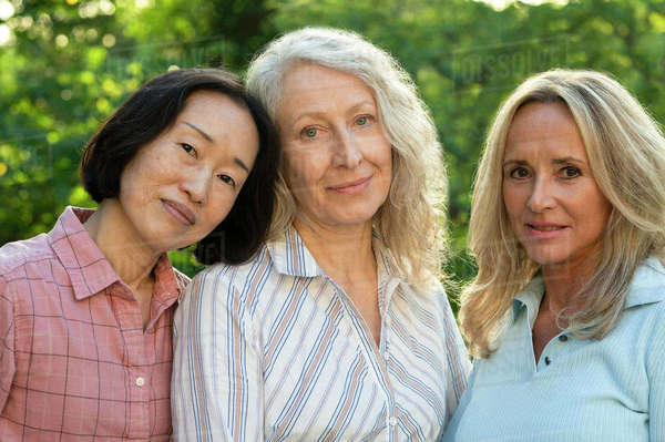 Group of three middle-aged women posing for photo in backyard - Royalty ...