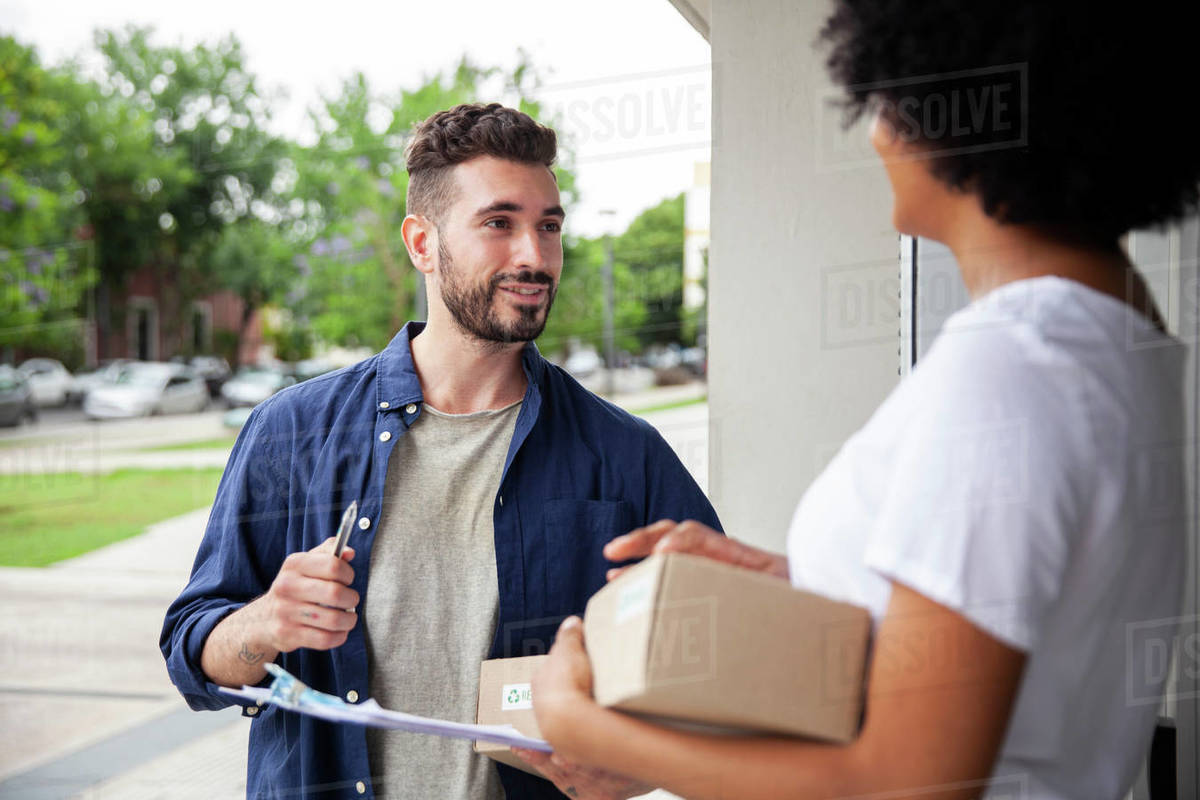 Delivery man talking with African American female customer - Royalty ...