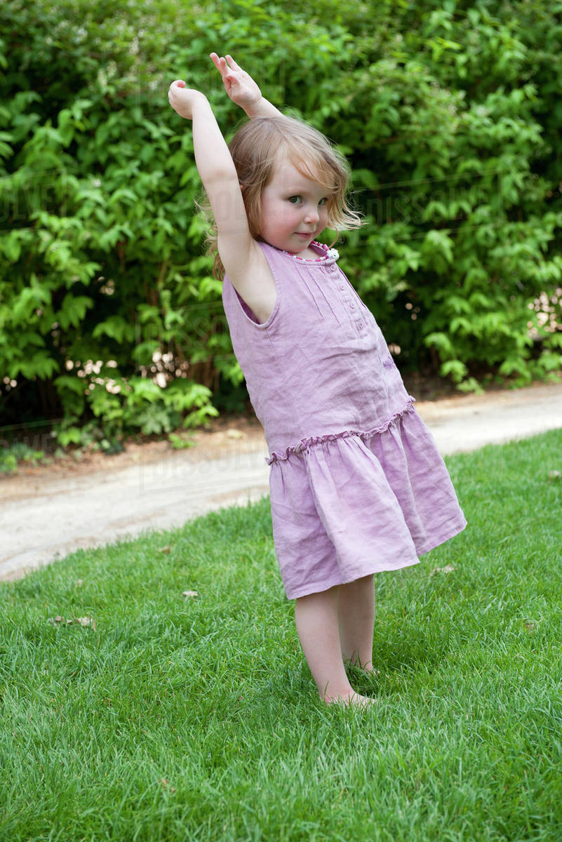 Little girl standing outdoors with arms raised - Royalty-free Stock ...