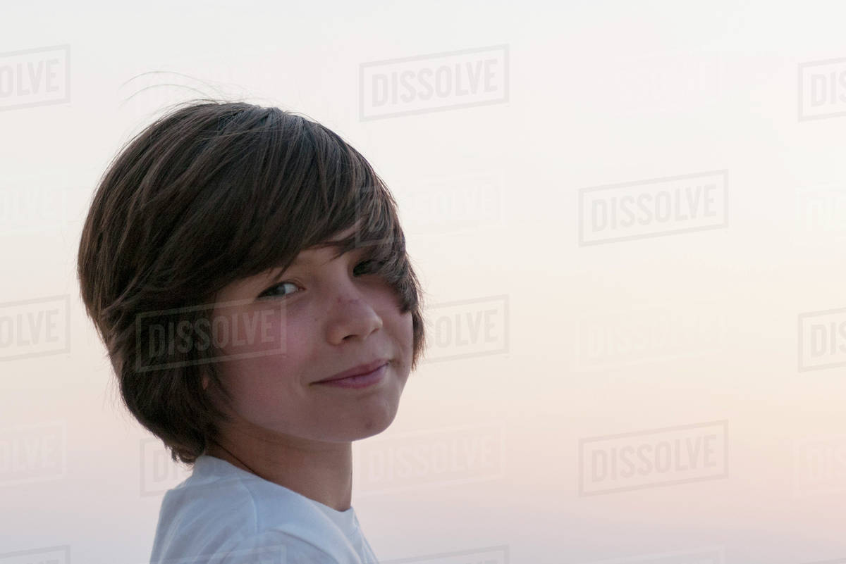 Teenage boy looking over shoulder, portrait - Stock Photo - Dissolve