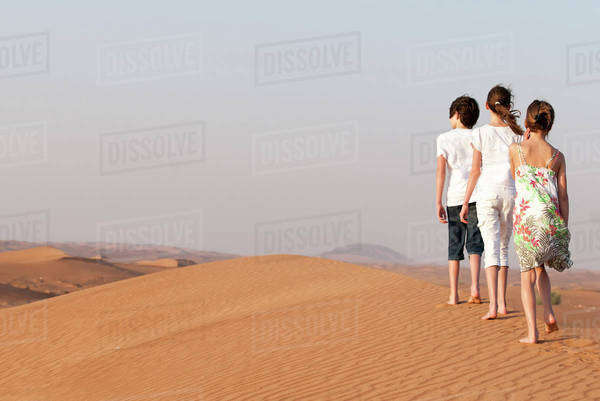 Children walking in desert, rear view - Royalty-free Stock Photo | Dissolve