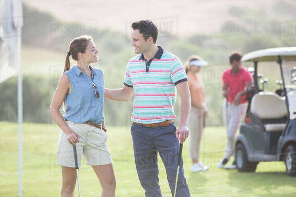 Friends playing golf on course - Royalty-free Stock Photo | Dissolve