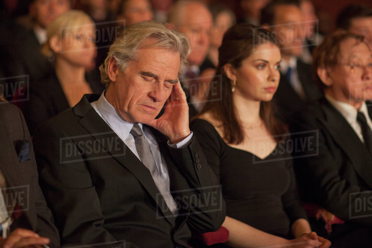 Man sleeping in theater audience - Stock Photo - Dissolve