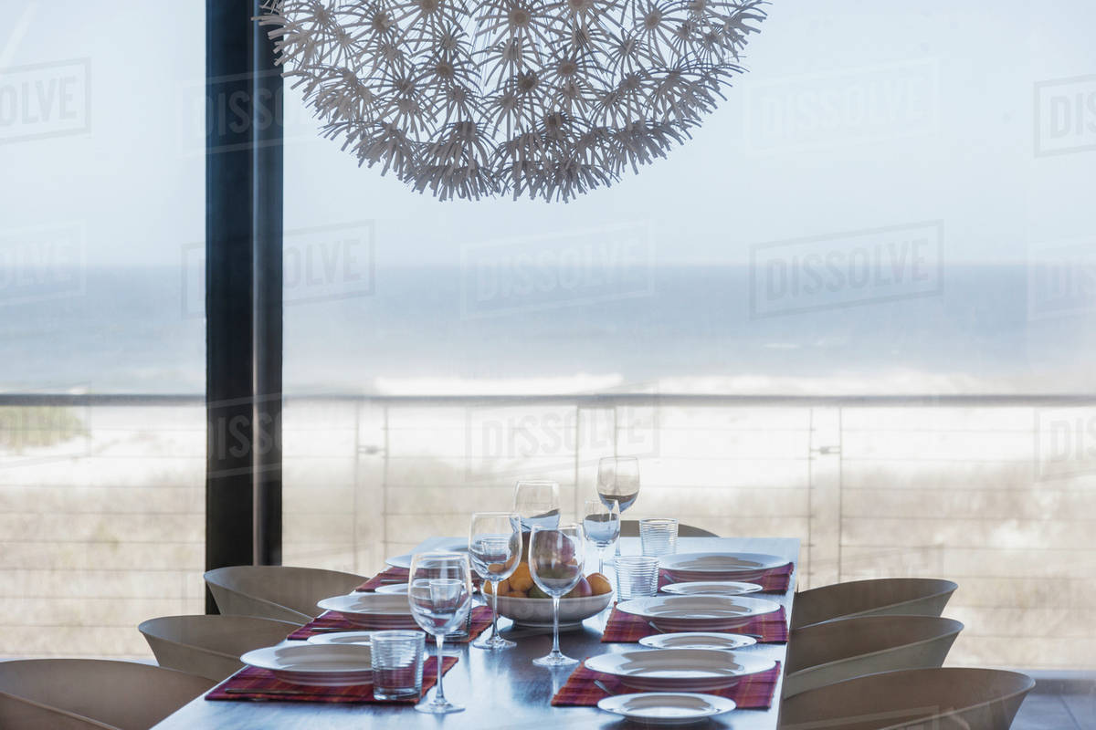 Set table in modern dining room overlooking ocean - Royalty-free Stock ...