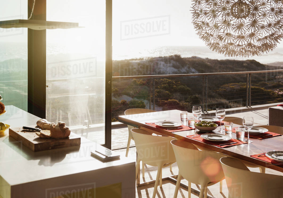 Modern dining room overlooking ocean at sunset - Royalty-free Stock ...