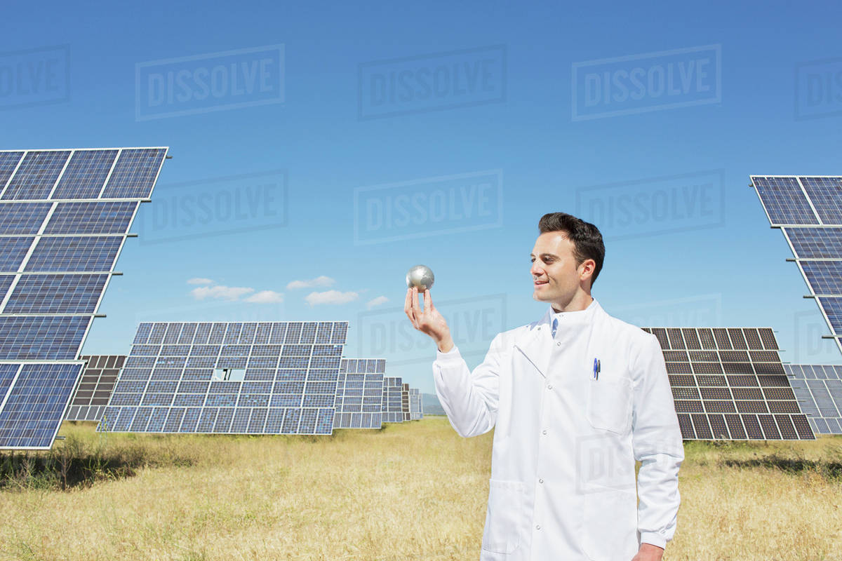 Scientist examining sphere by solar panels - Royalty-free Stock Photo ...