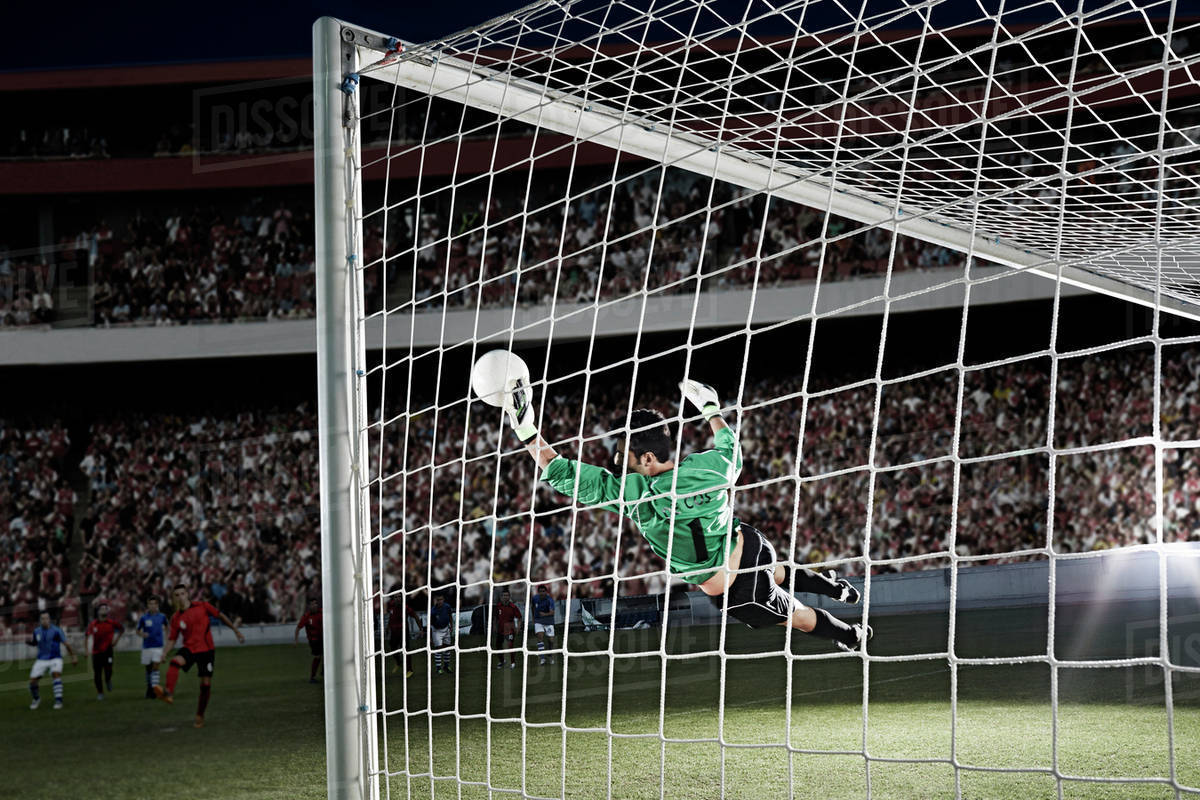 Goalie defending soccer net on field - Royalty-free Stock Photo | Dissolve