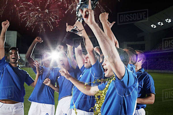 Soccer team cheering with trophy on field - Royalty-free Stock Photo ...