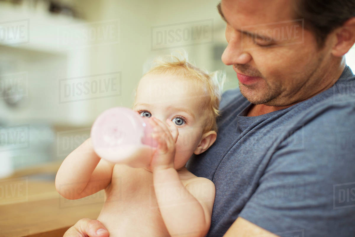 Father feeding baby in kitchen - Stock Photo - Dissolve