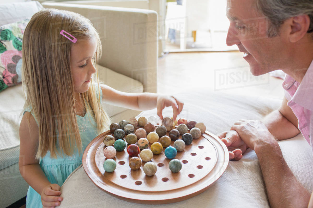Father and daughter playing Chinese checkers - Stock Photo - Dissolve