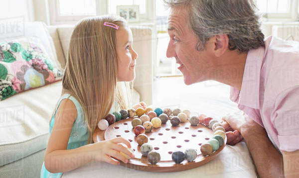 Father and daughter playing Chinese checkers - Stock Photo - Dissolve