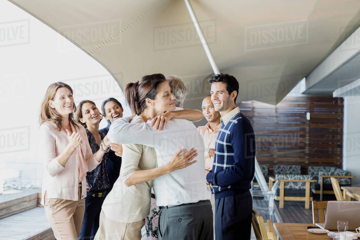 Business people hugging in office - Royalty-free Stock Photo | Dissolve