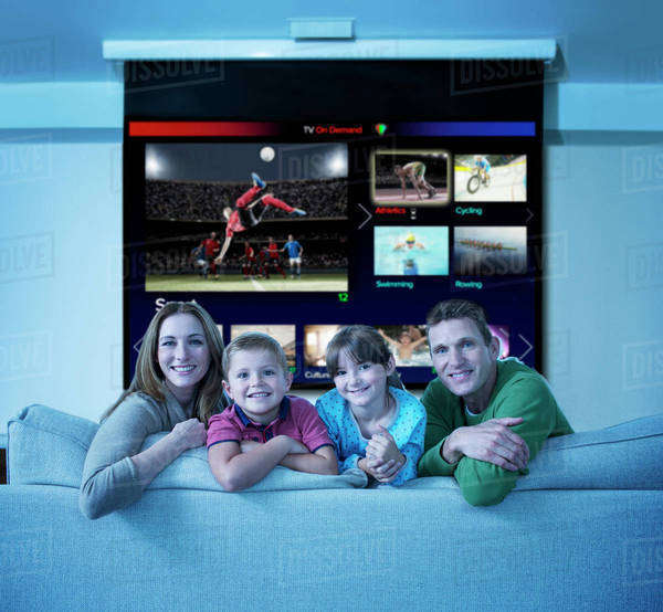 Family watching multi screen television in living room - Stock Photo ...