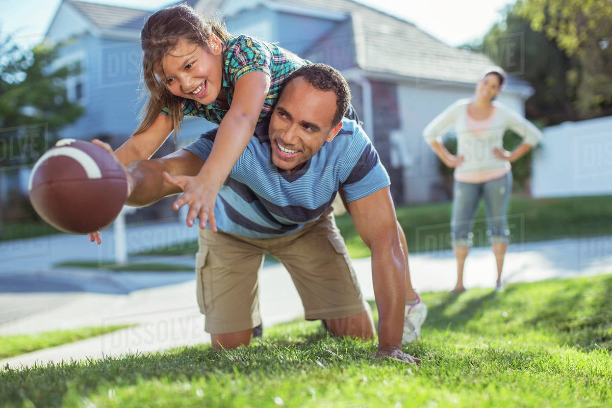 Father and daughter playing football in yard - Royalty-free Stock Photo ...