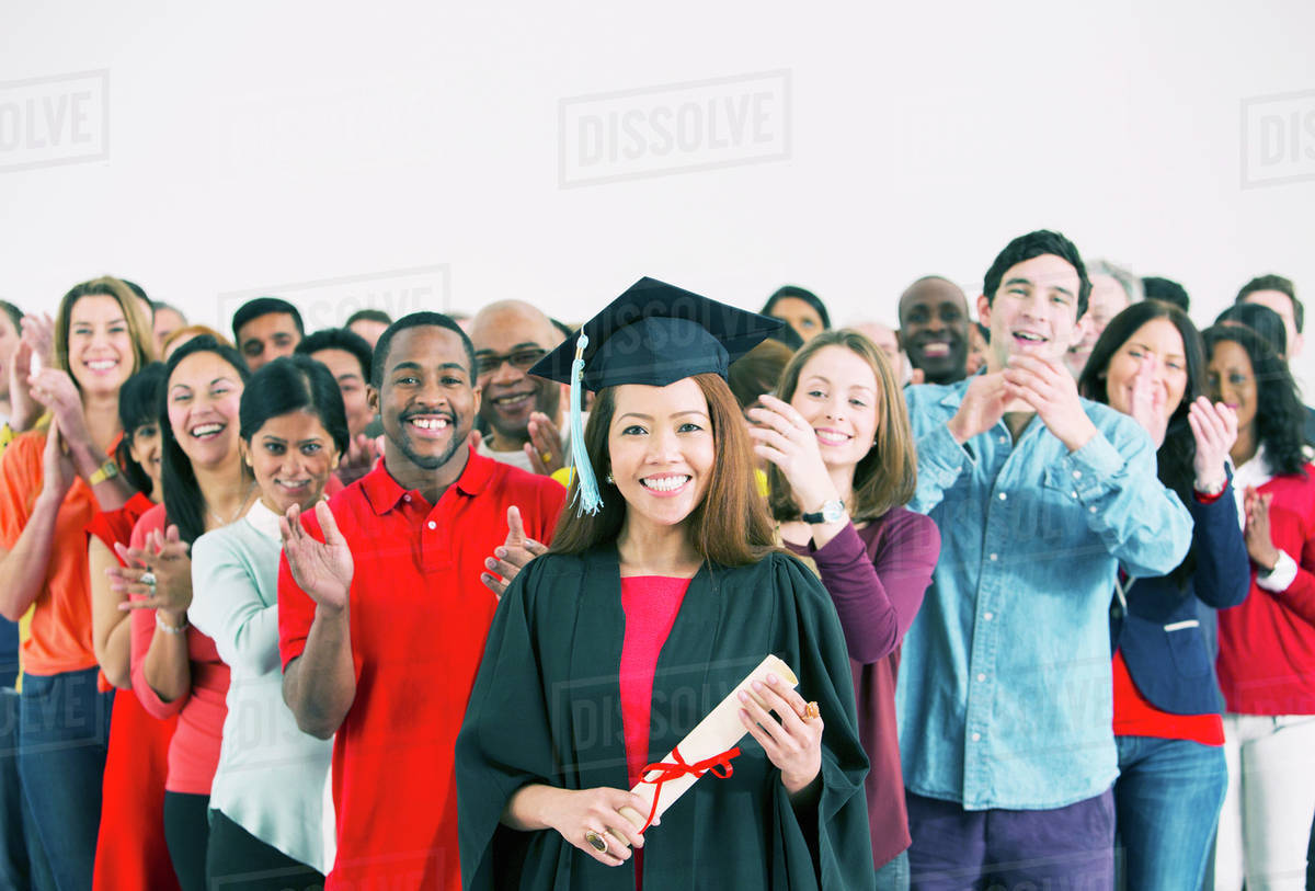 Crowd clapping behind happy graduate - Stock Photo - Dissolve