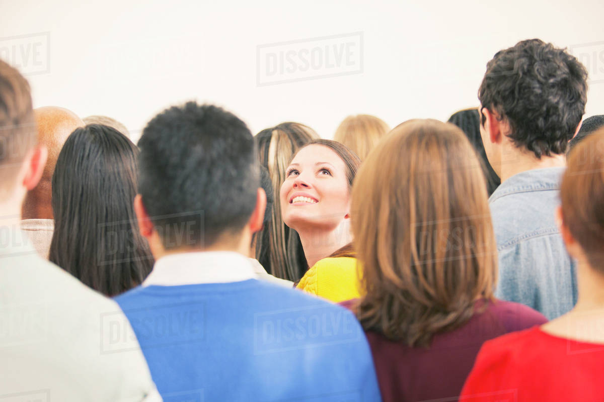 Confident woman looking up in crowd - Royalty-free Stock Photo | Dissolve