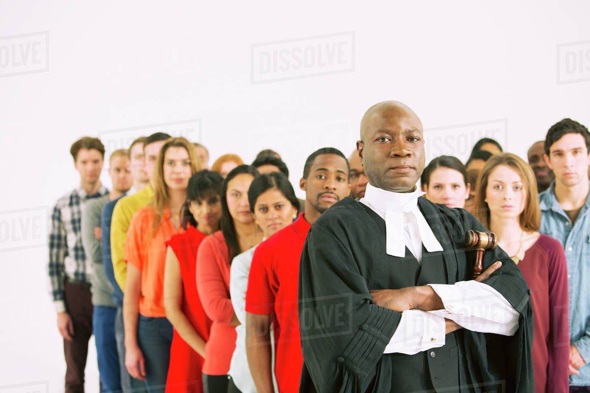 Serious judge in front of crowd - Stock Photo - Dissolve