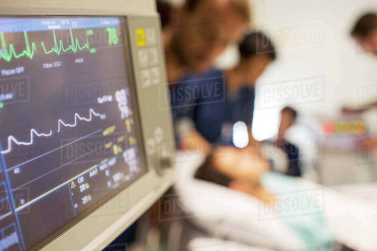 Heart rate monitor, patient and doctors in background in intensive care ...