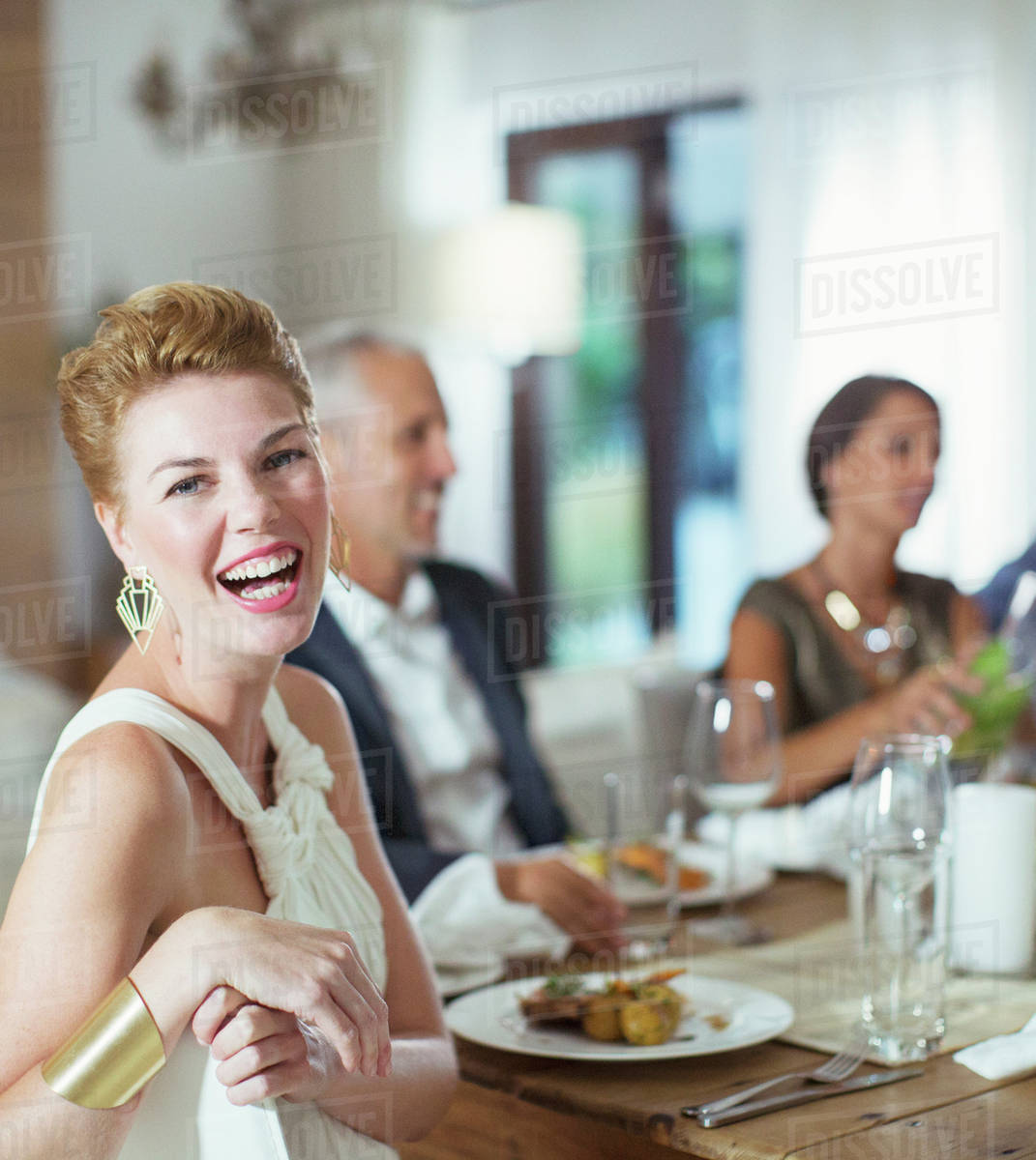 Woman laughing at dinner party - Royalty-free Stock Photo | Dissolve