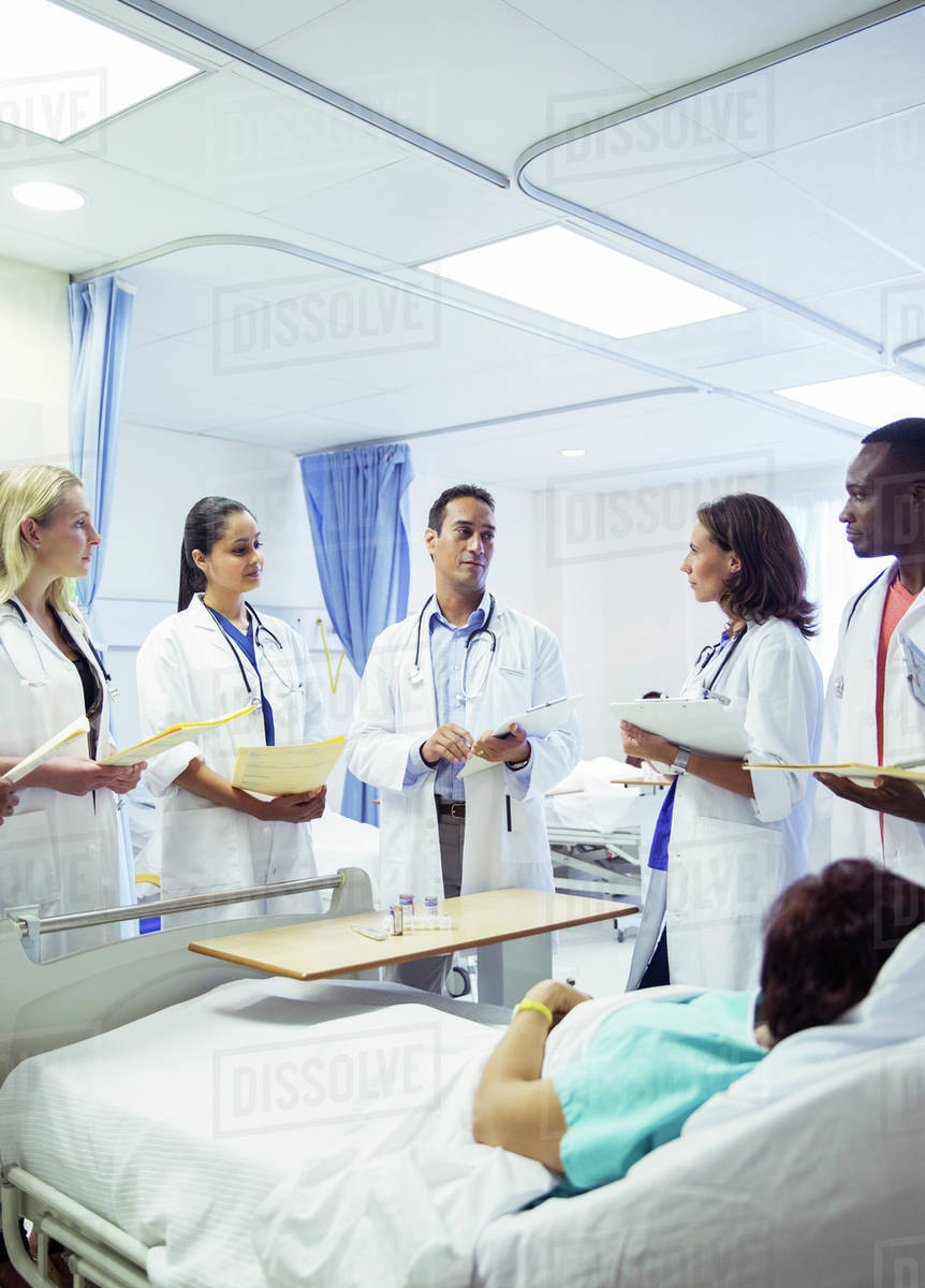 Doctor teaching residents in hospital room - Stock Photo - Dissolve
