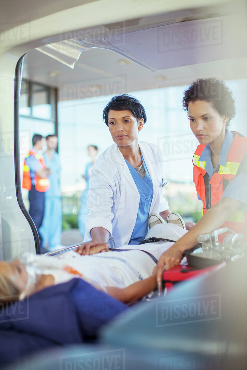 Doctor and paramedic examining patient in ambulance - Royalty-free ...