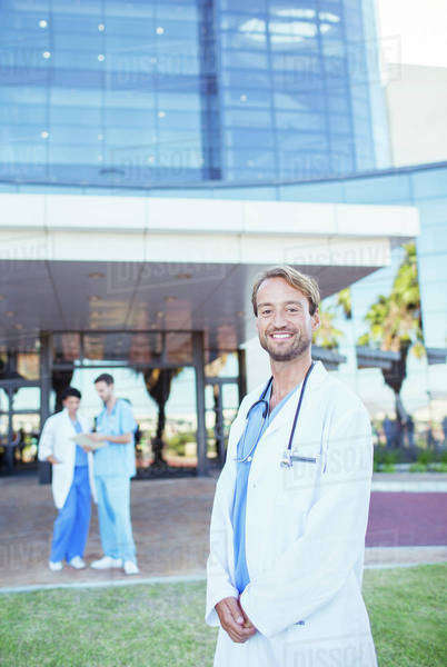 Doctor smiling outside hospital - Royalty-free Stock Photo | Dissolve