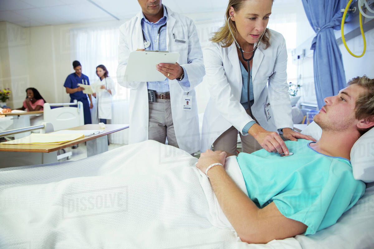Doctors examining patient in hospital room - Royalty-free Stock Photo ...