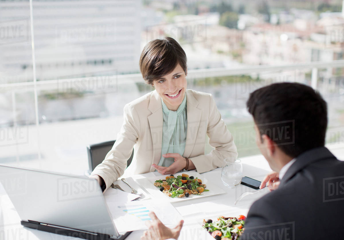 Businessman and businesswoman with laptop meeting over lunch - Royalty ...