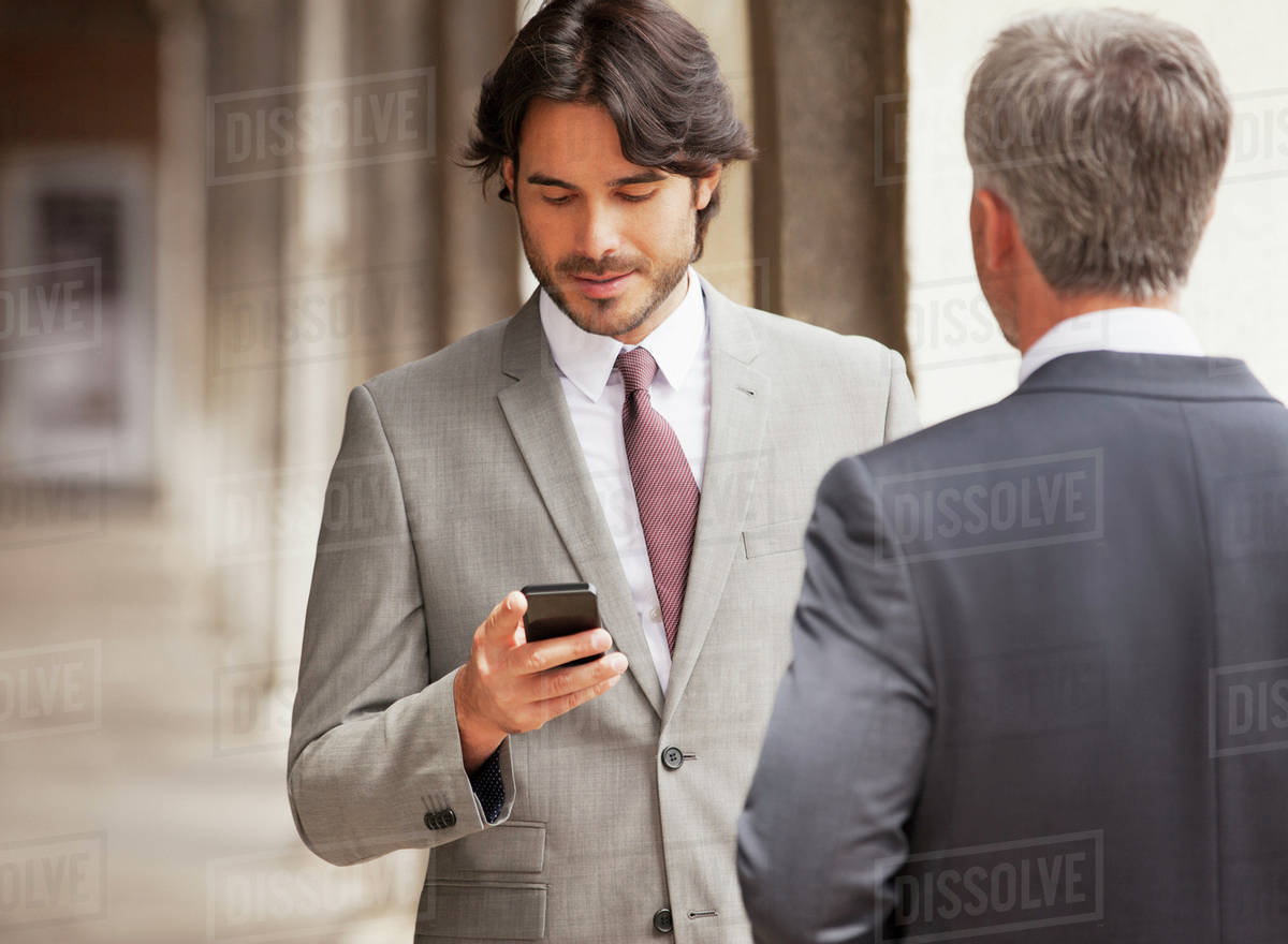 Businessman checking cell phone - Royalty-free Stock Photo | Dissolve