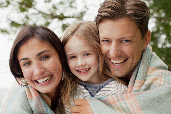 Close up portrait of smiling family wrapped in blanket - Royalty-free ...