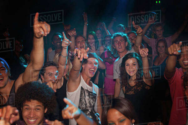 Enthusiastic crowd cheering at concert - Stock Photo - Dissolve