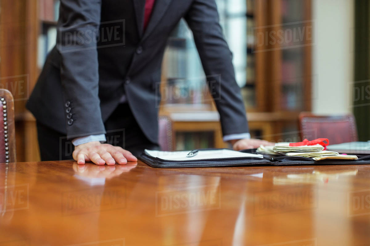 Lawyer leaning on table in chambers - Royalty-free Stock Photo | Dissolve