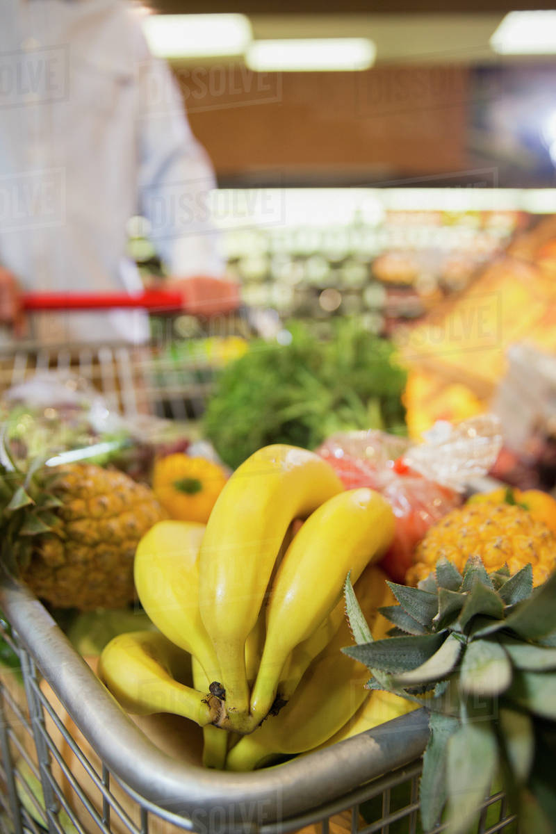 Close up of full shopping cart in grocery store - Stock Photo - Dissolve