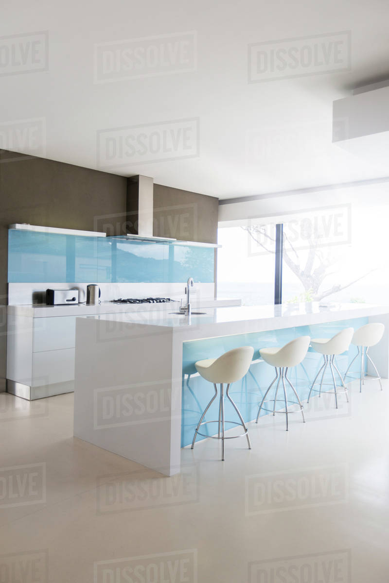 White and clean modern kitchen with stools at kitchen island - Royalty ...