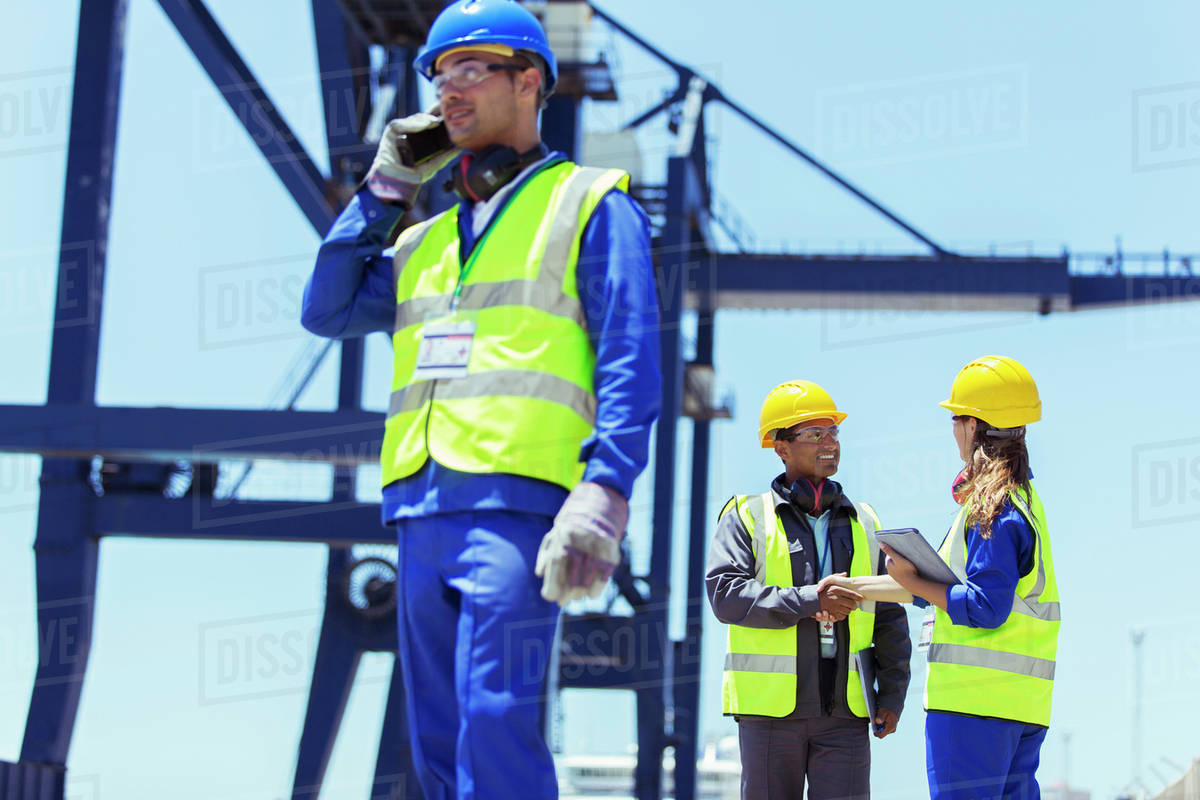 Worker using walkie-talkie near cargo crane - Royalty-free Stock Photo ...