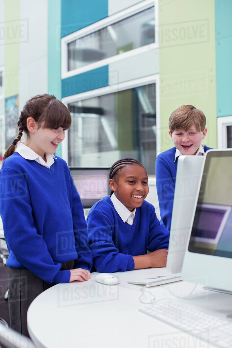 Primary school children looking at computer and smiling - Royalty-free ...