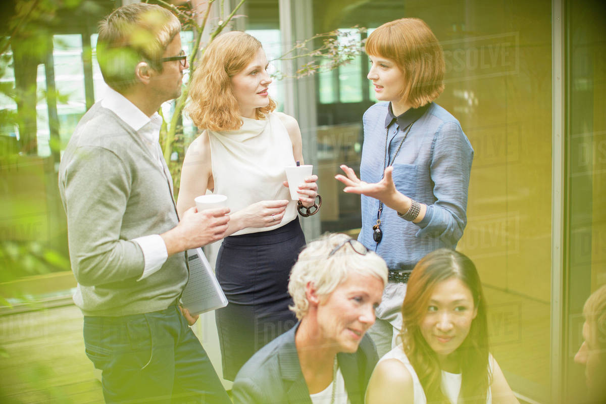 Business people talking in courtyard - Royalty-free Stock Photo | Dissolve