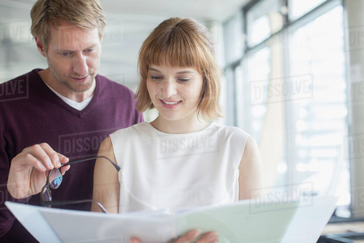 Business people reading paperwork in office - Stock Photo - Dissolve