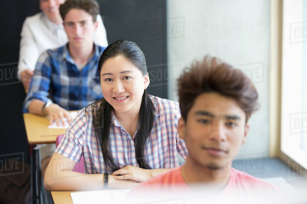 Portrait of smiling university students sitting in classroom - Royalty ...