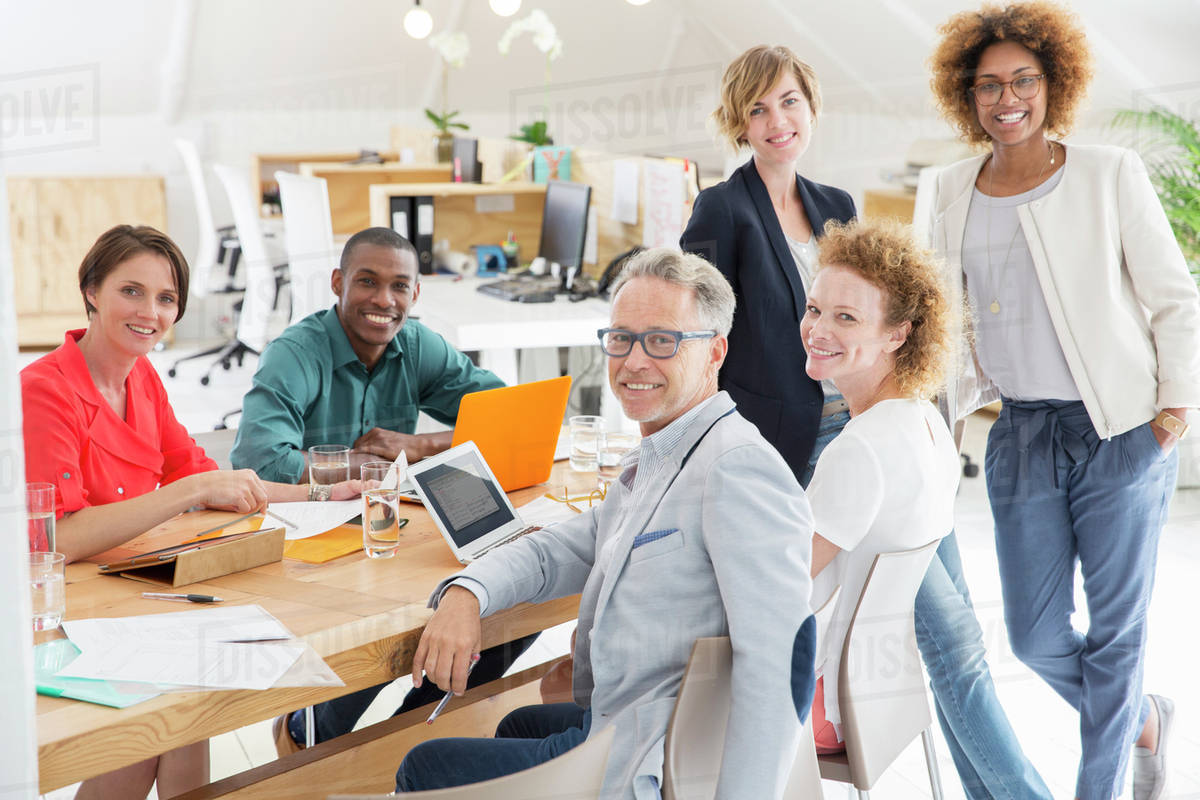 Group portrait of smiling office workers at table - Royalty-free Stock ...