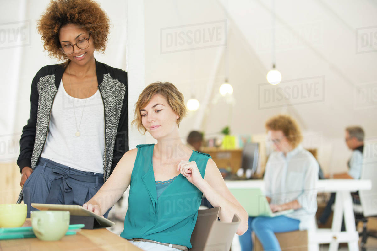 Two office workers talking at desk using tablet - Royalty-free Stock ...