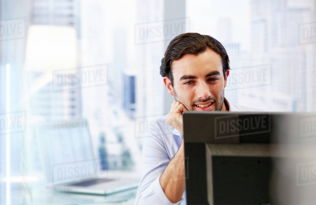 Man using computer in office - Royalty-free Stock Photo | Dissolve