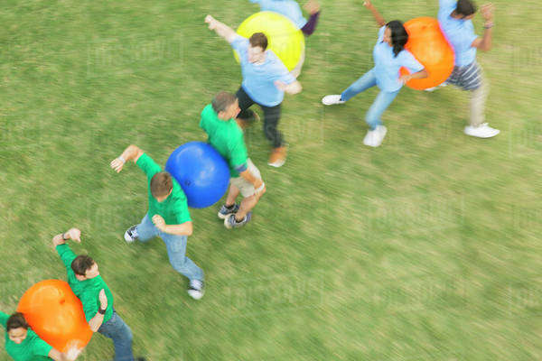 Teammates performing fitness ball team building activity - Stock Photo ...