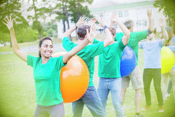 Teammates performing fitness ball team building activity - Royalty-free ...