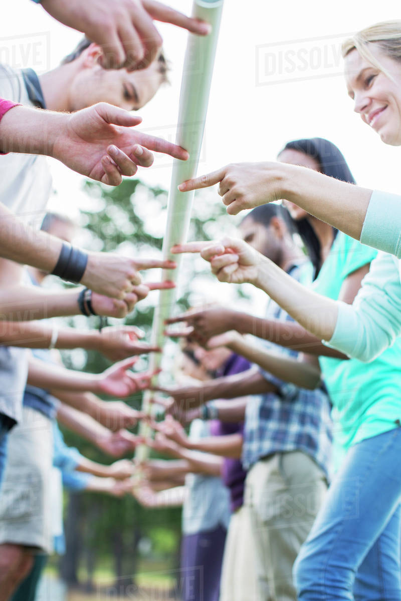 Team balancing pole with fingertips - Royalty-free Stock Photo | Dissolve