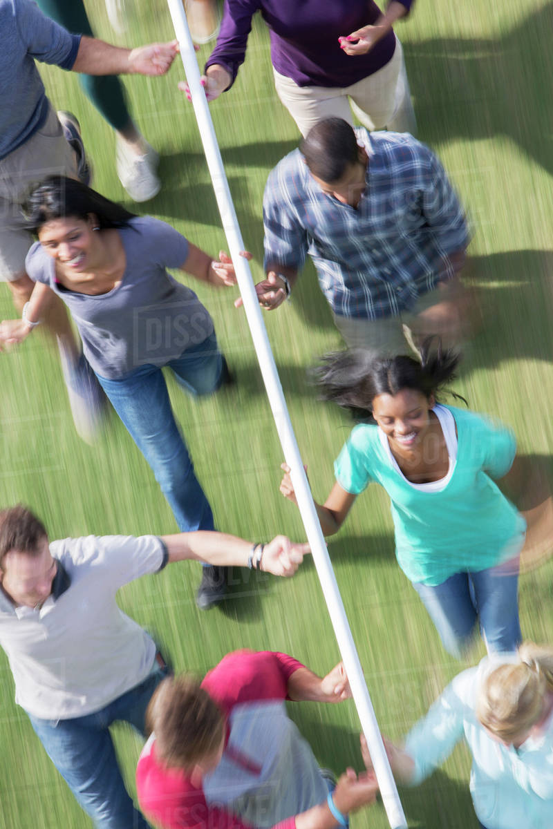 Smiling team running and balancing pole on fingertips - Stock Photo ...