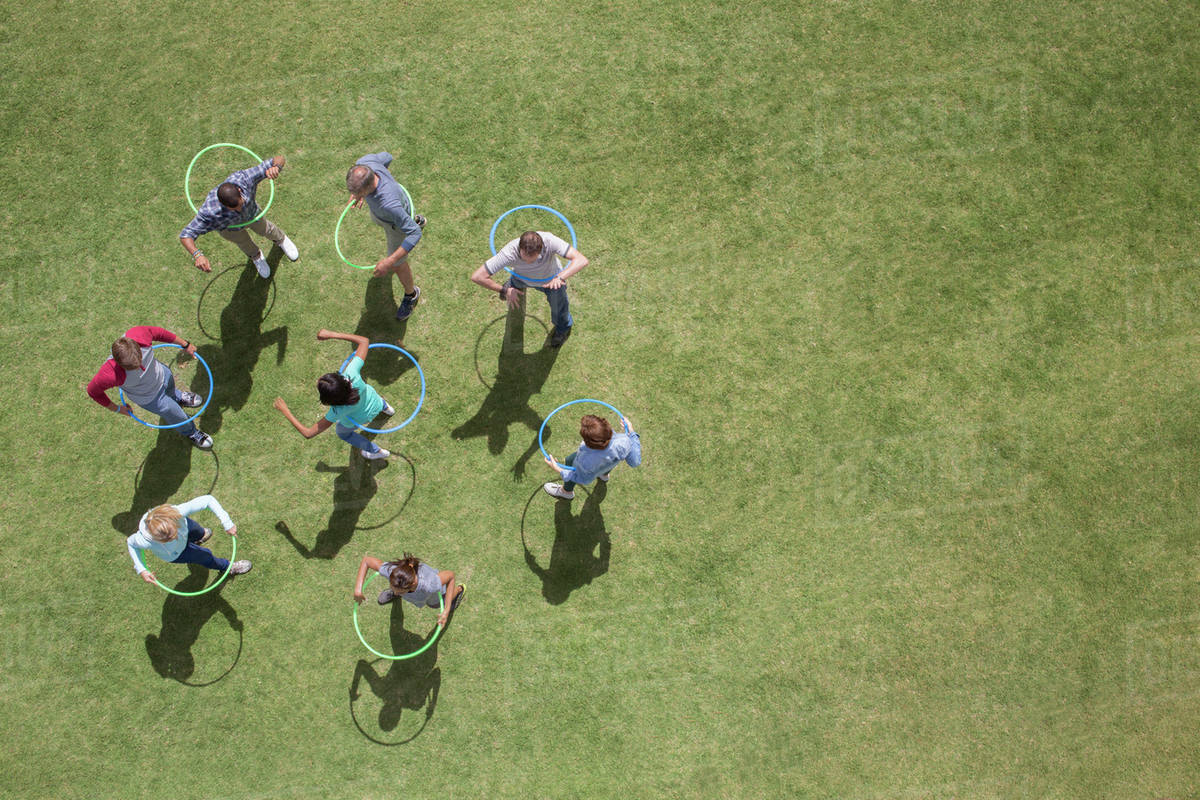 People spinning in plastic hoops in sunny grass - Royalty-free Stock ...