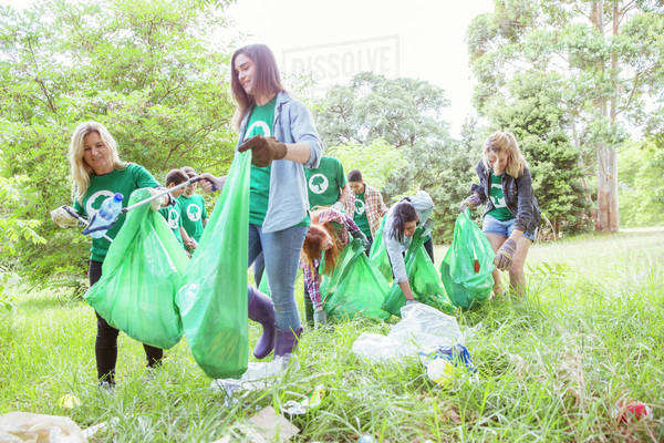 Environmentalist volunteers picking up trash in field - Royalty-free ...
